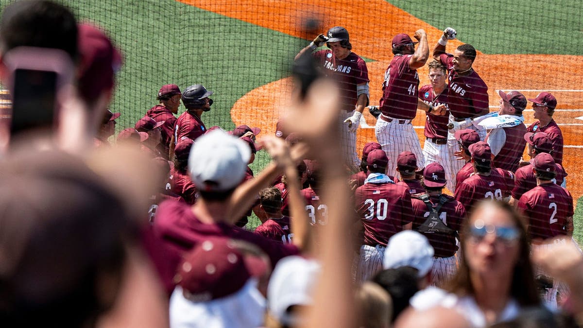 Little Rock baseball team celebrates with bus driver on the field after ...